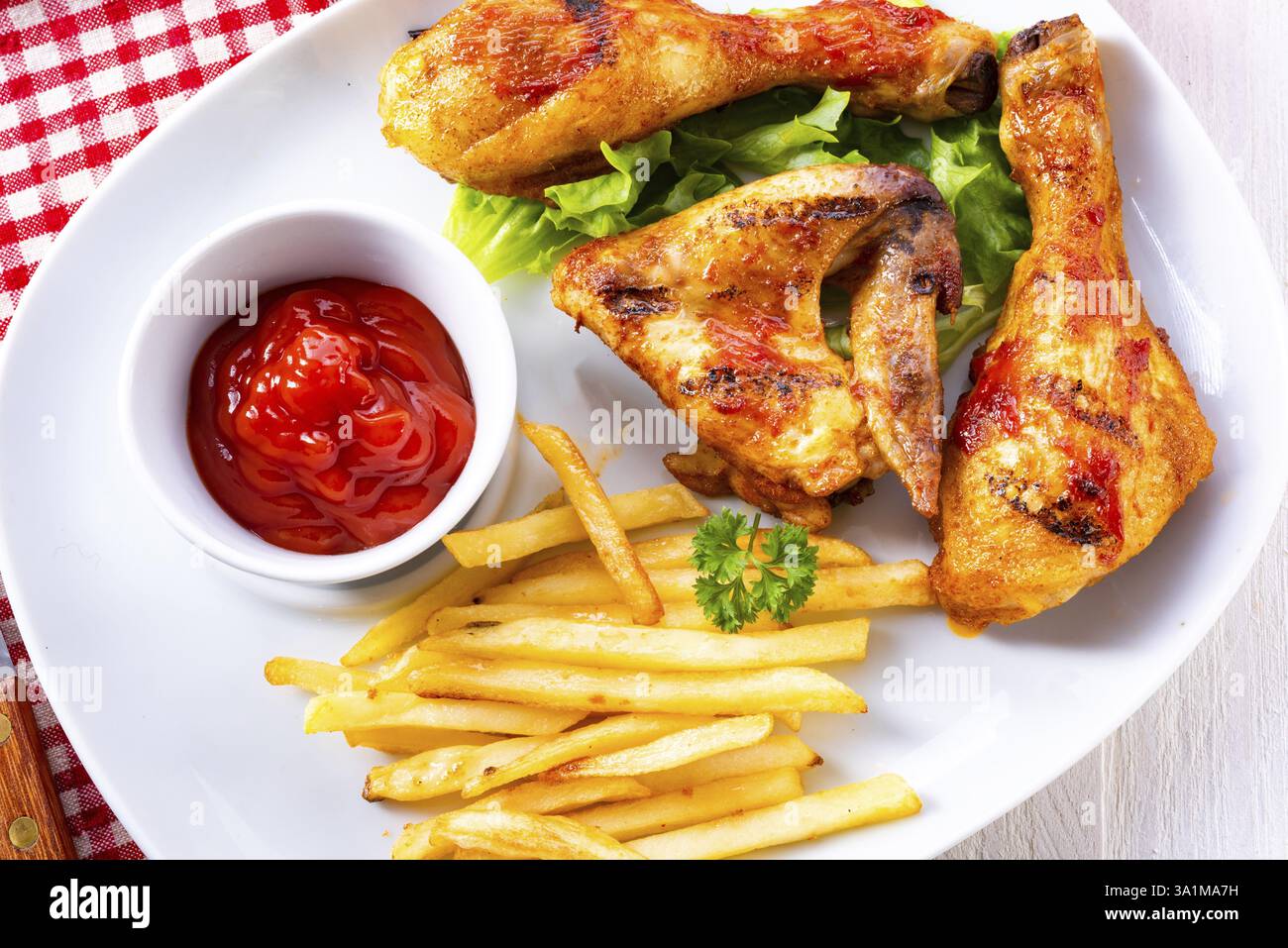 Grilled chicken wings, legs, chips and vegetables Stock Photo - Alamy