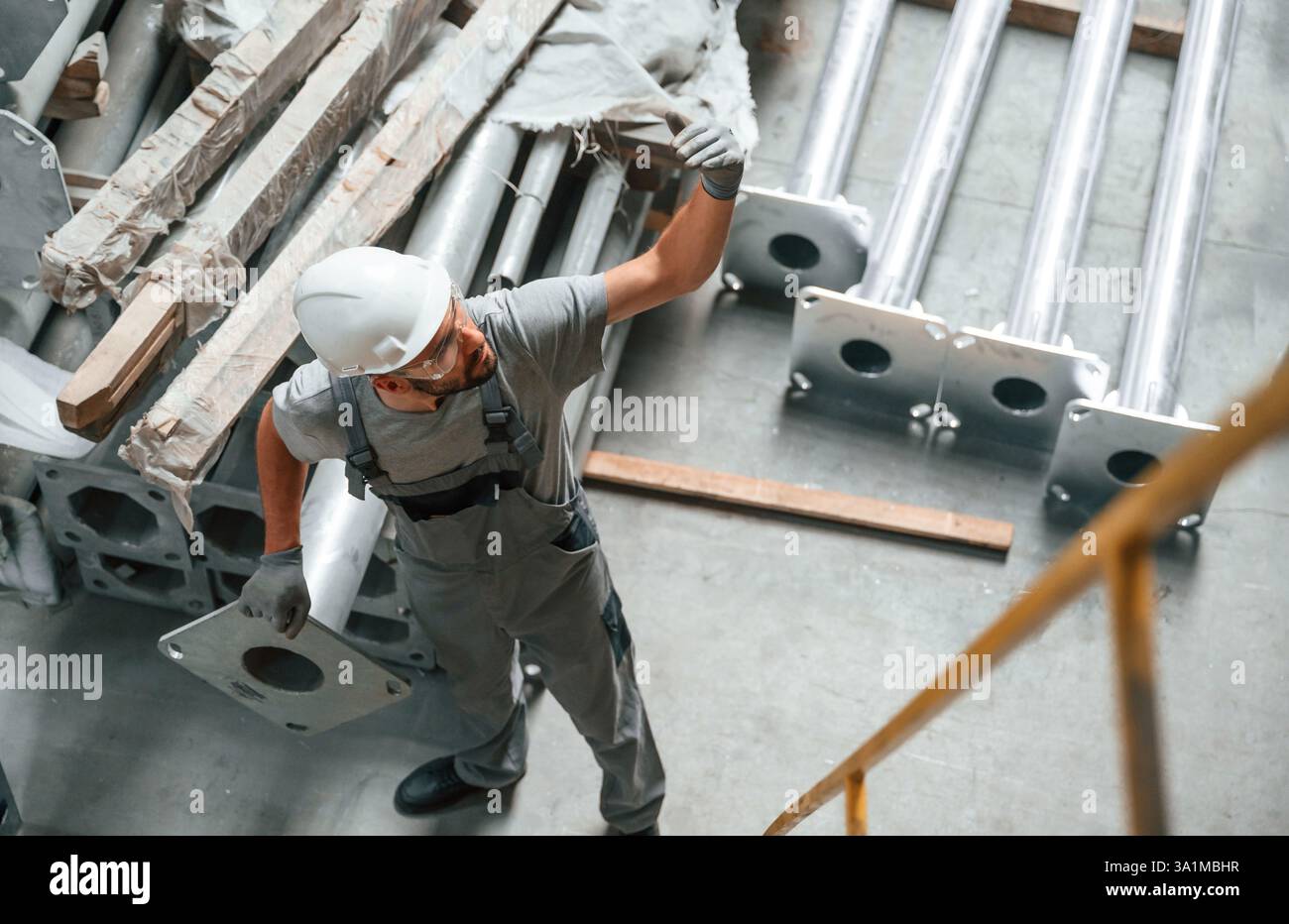 Making gesture by hands. Young factory worker in grey uniform Stock ...