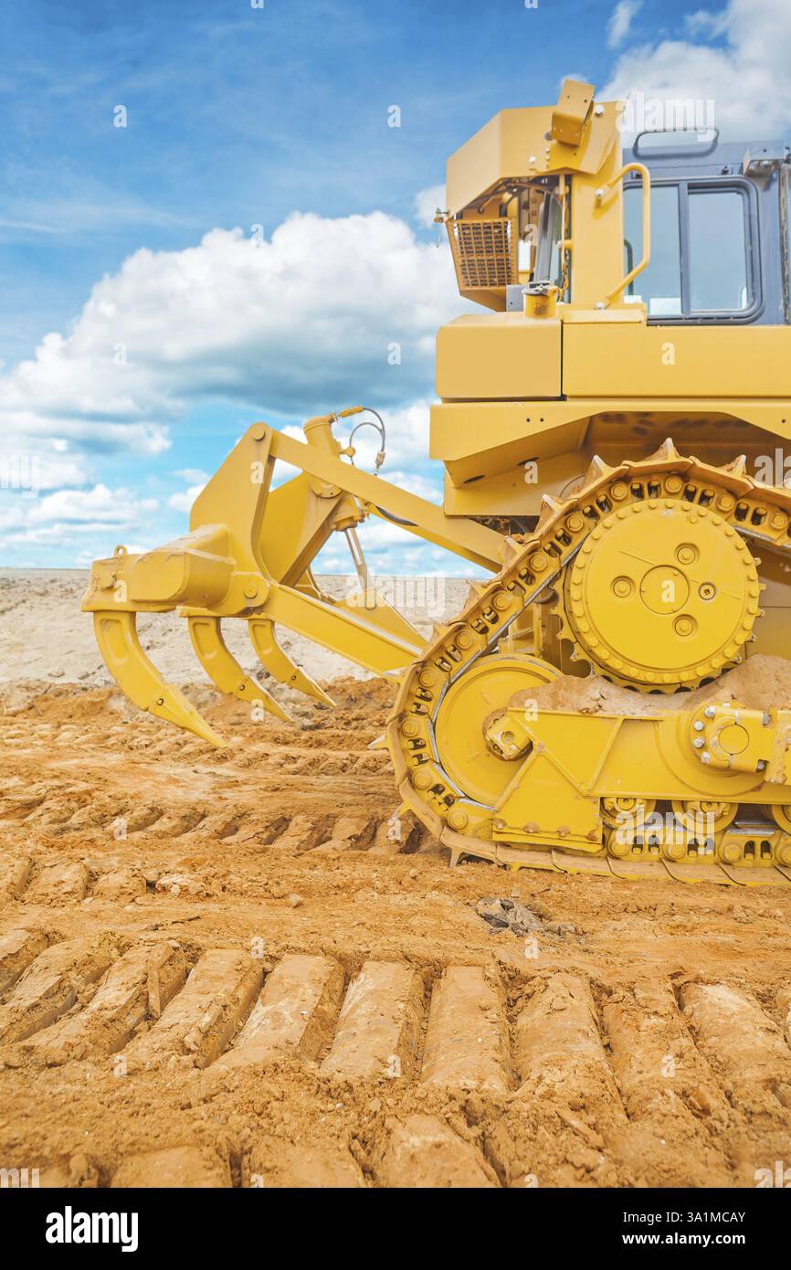 Part of bulldozer standing on sand at construction site rear view with ...