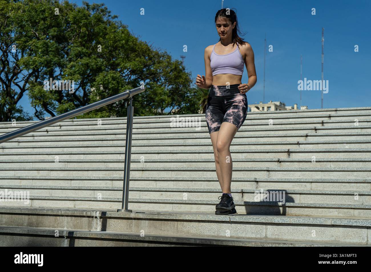 Fit woman improving her physical condition by climbing stairs in an ...