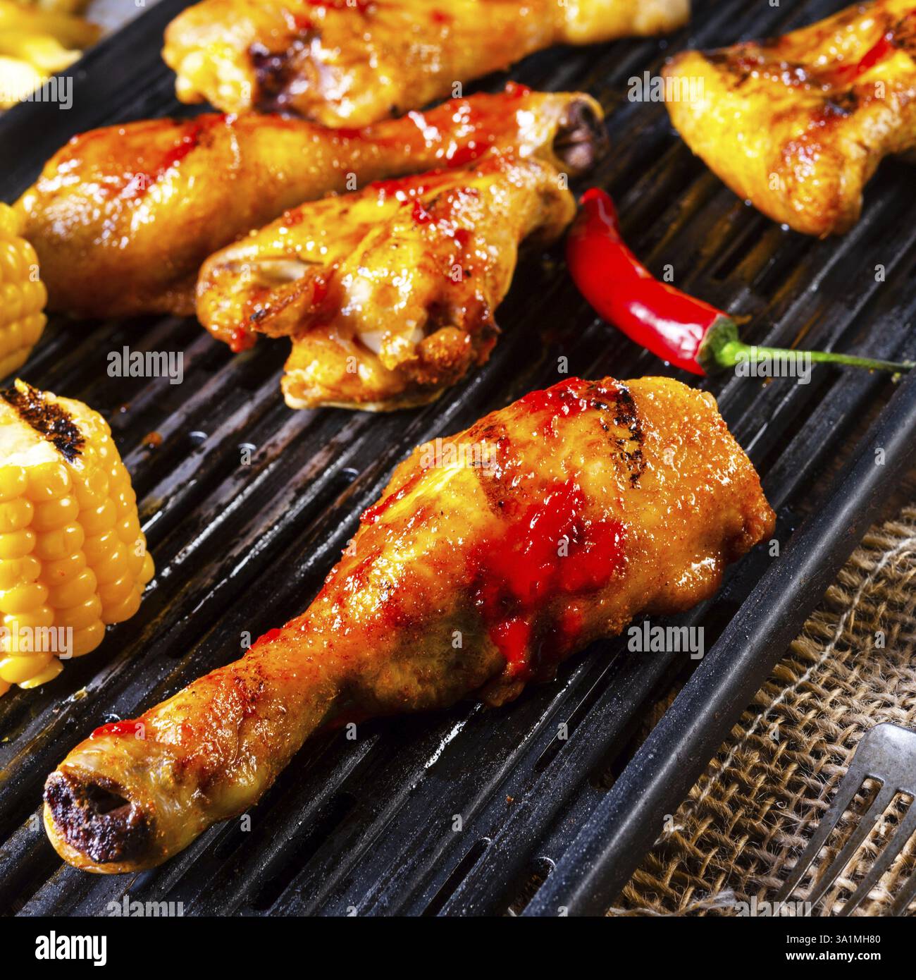 Rustic Grilled chicken wings, legs, and spicy corn Stock Photo - Alamy