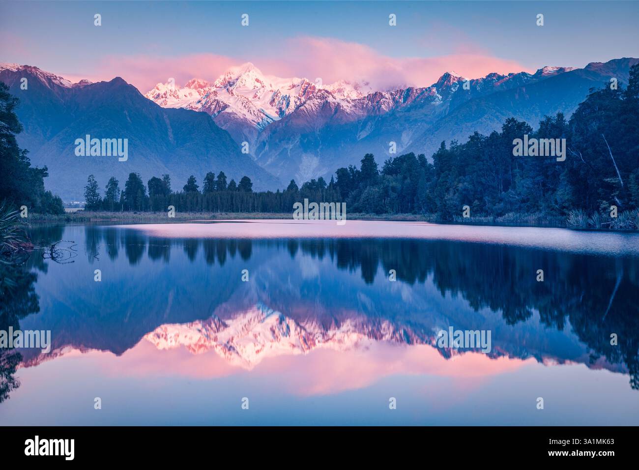 Lake Matheson at sunset with snow covered Mount Tasman and, in the ...