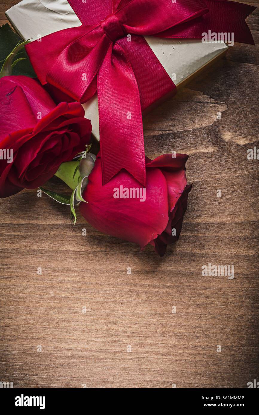 Packed present with red ribbon natural bloomed roses holiday concept ...