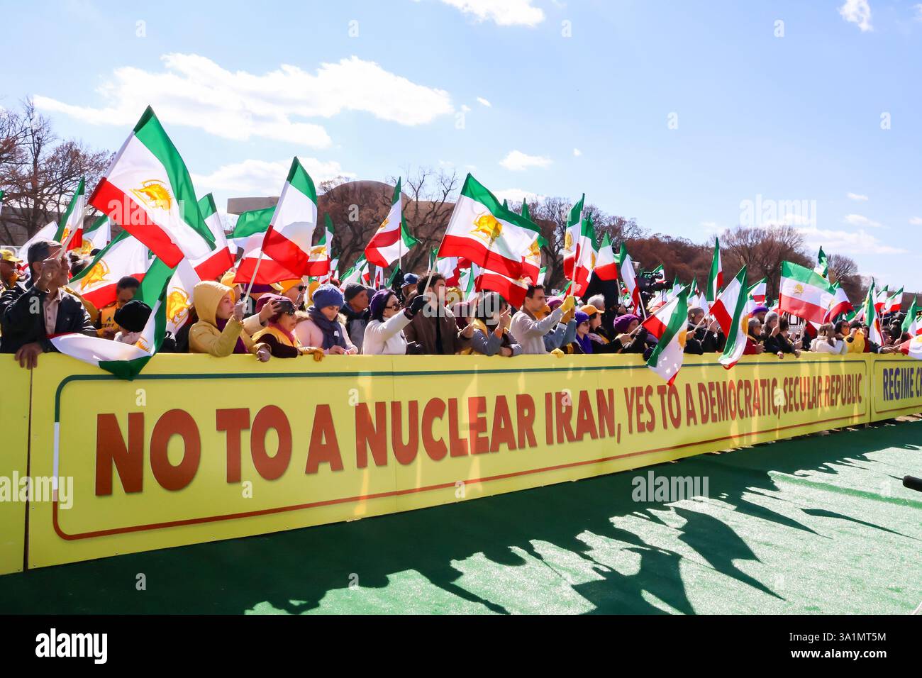 Iranians are seen waving Iran's flag with the sun and lion signs ...