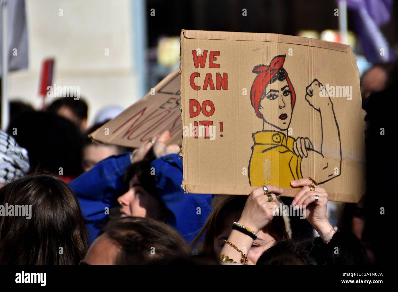 A woman holds a placard saying "we can do it" during the demonstration ...
