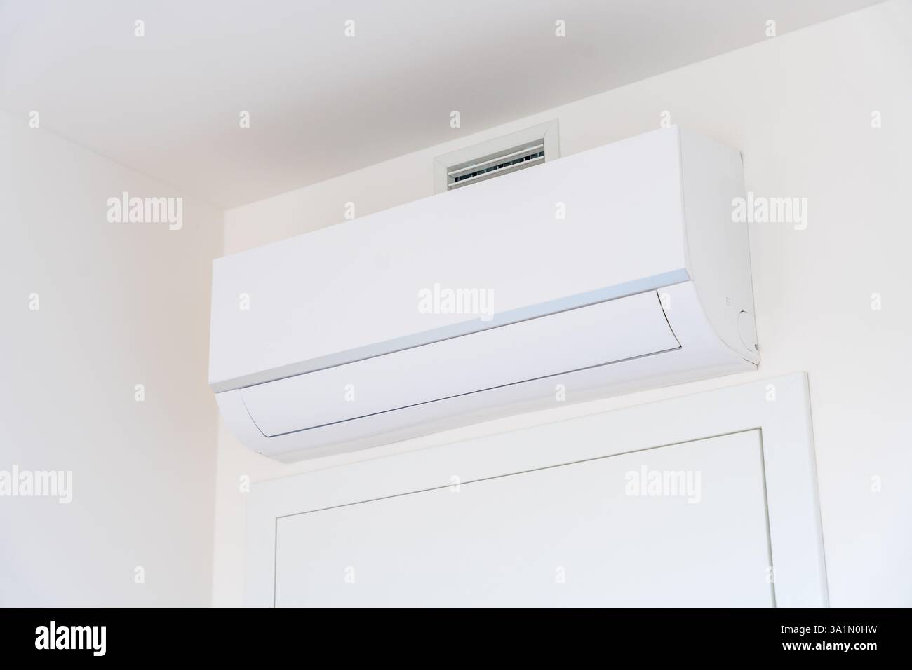 Modern white wall-mounted air conditioner unit in a home interior Stock ...