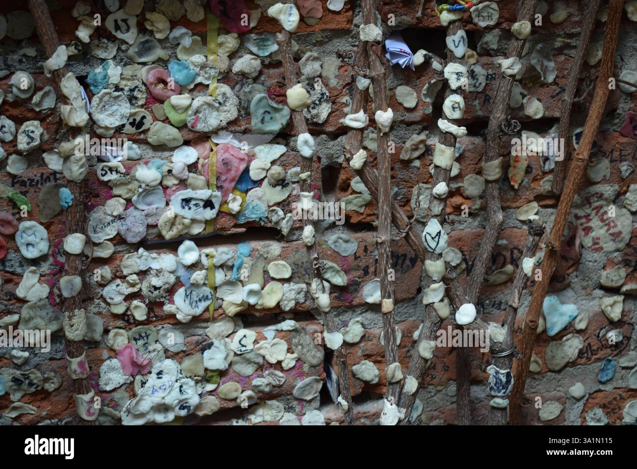 A colorful wall entirely covered in layers of stuck chewing gum, a ...