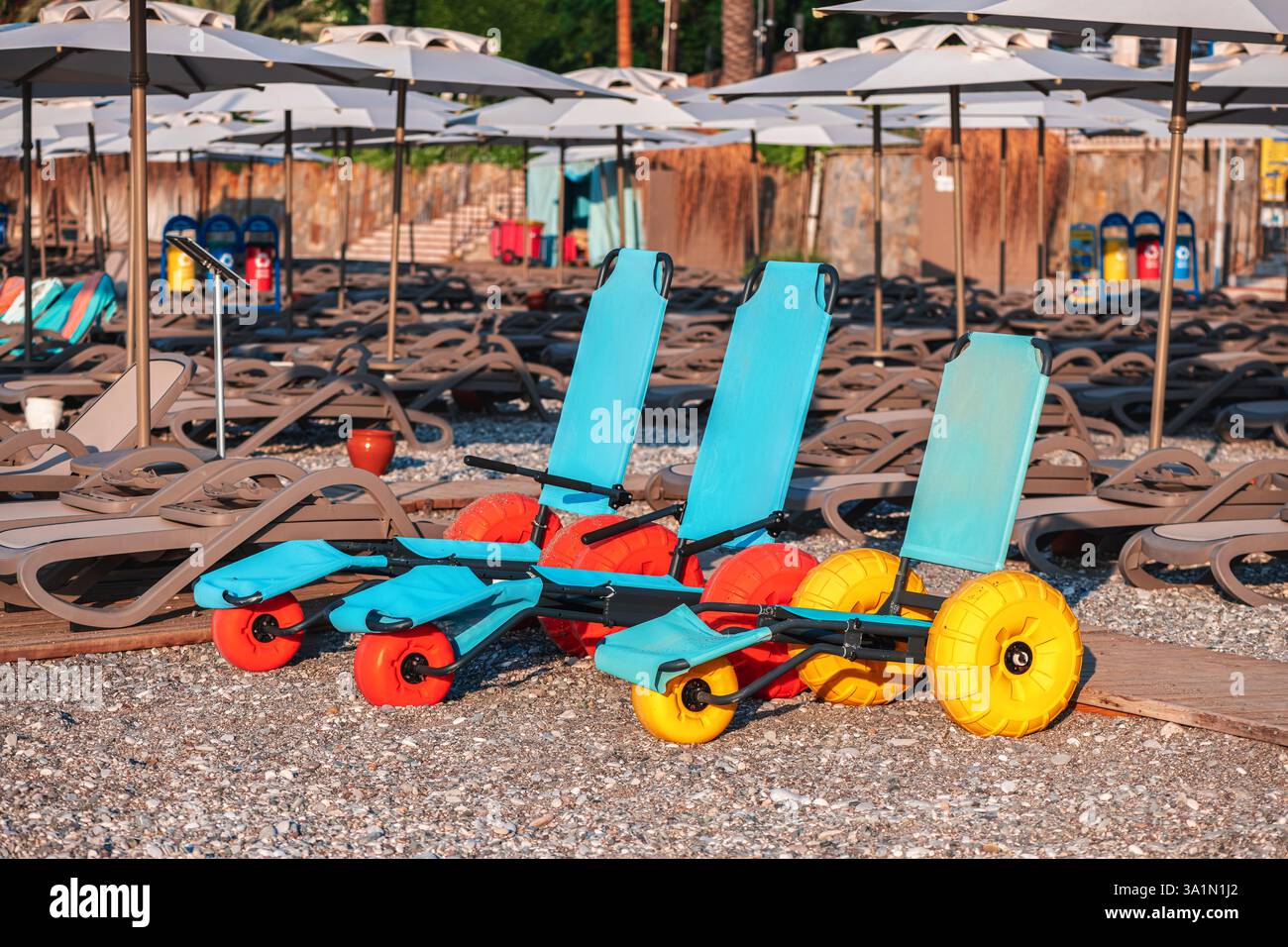 Floating beach wheelchairs are standing on a pebble beach, offering ...