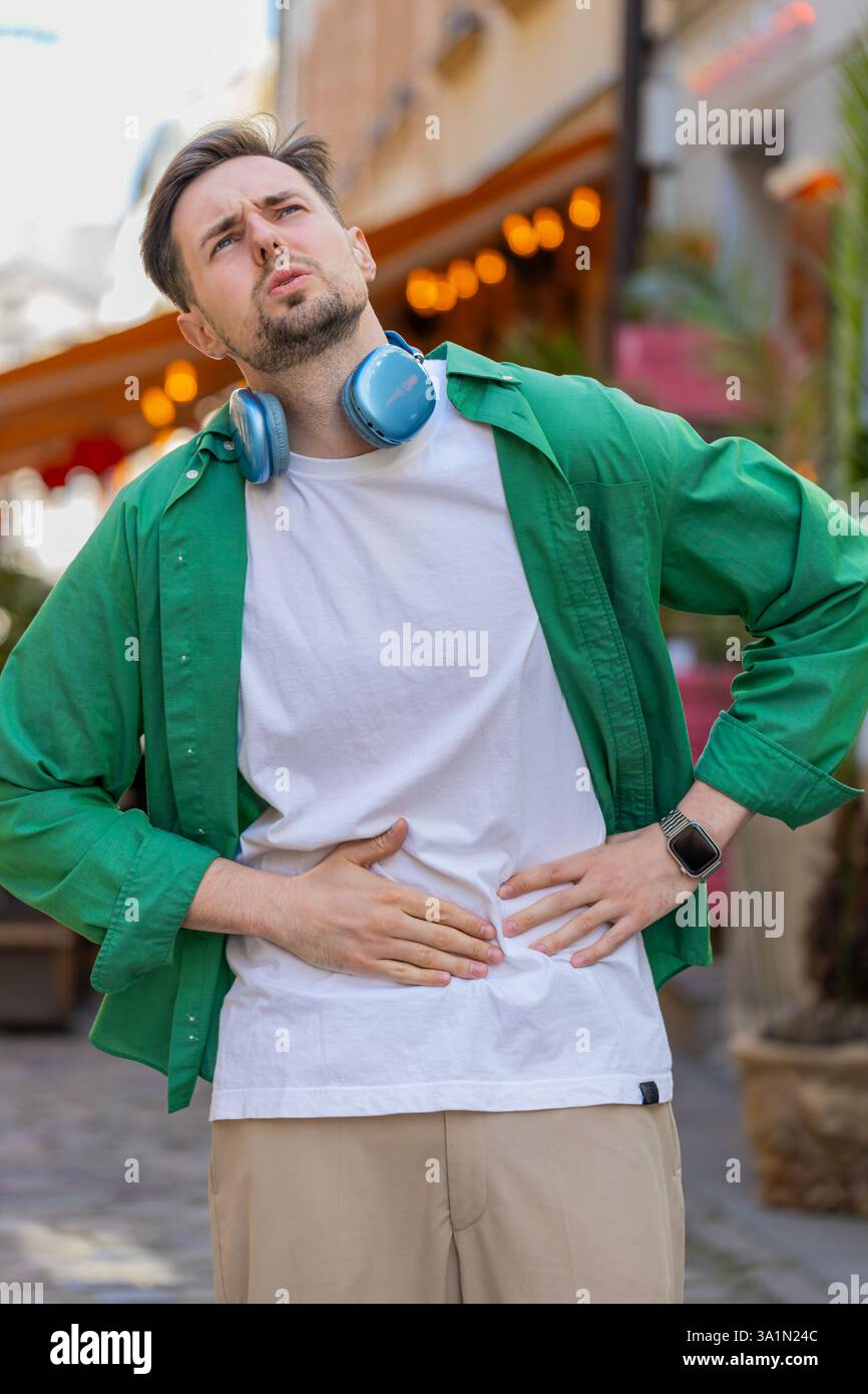 Caucasian young man traveler feeling sudden strong abdominal stomach ...