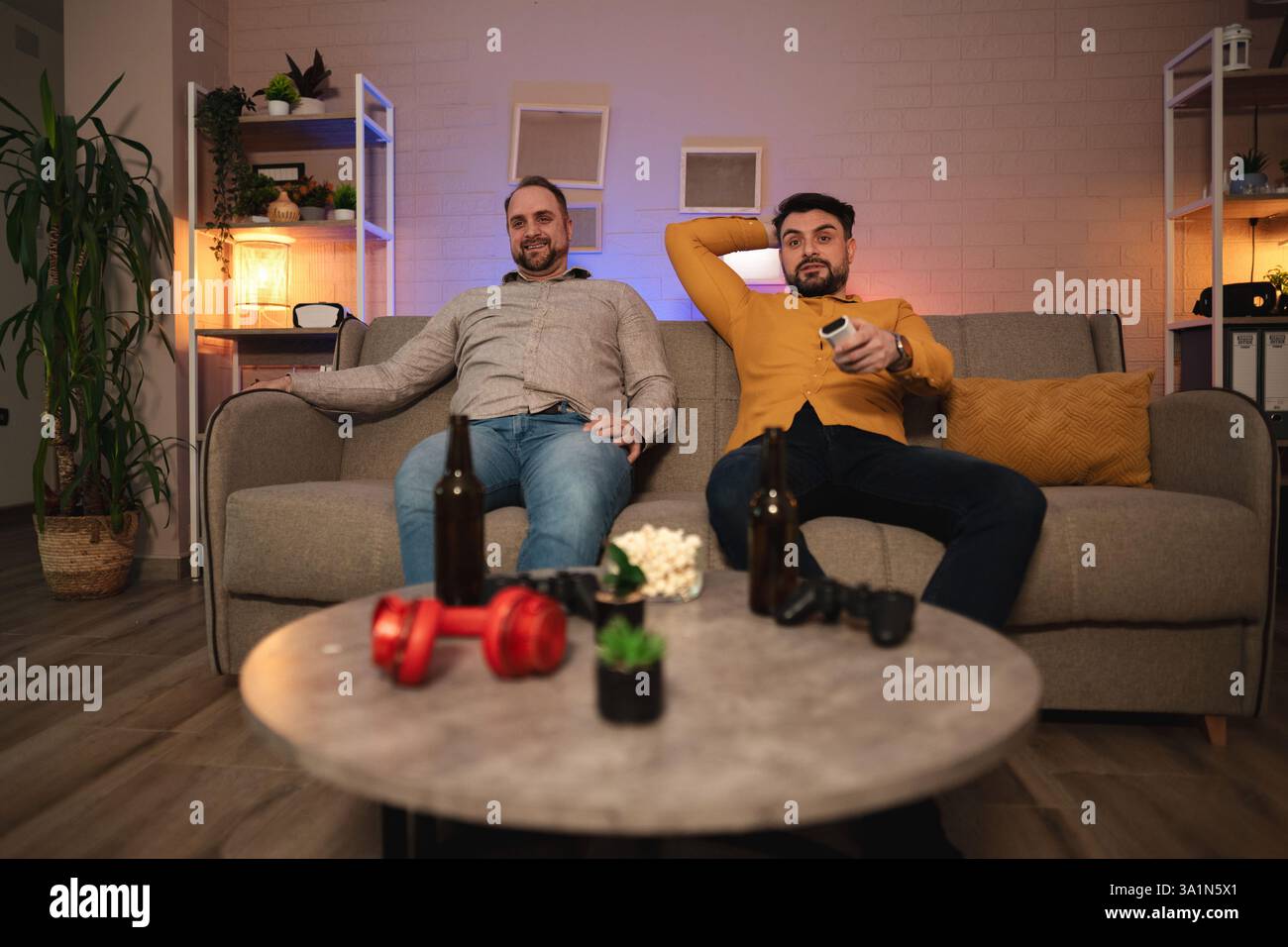 Friends relax on a cozy couch, enjoying a gaming night filled with ...