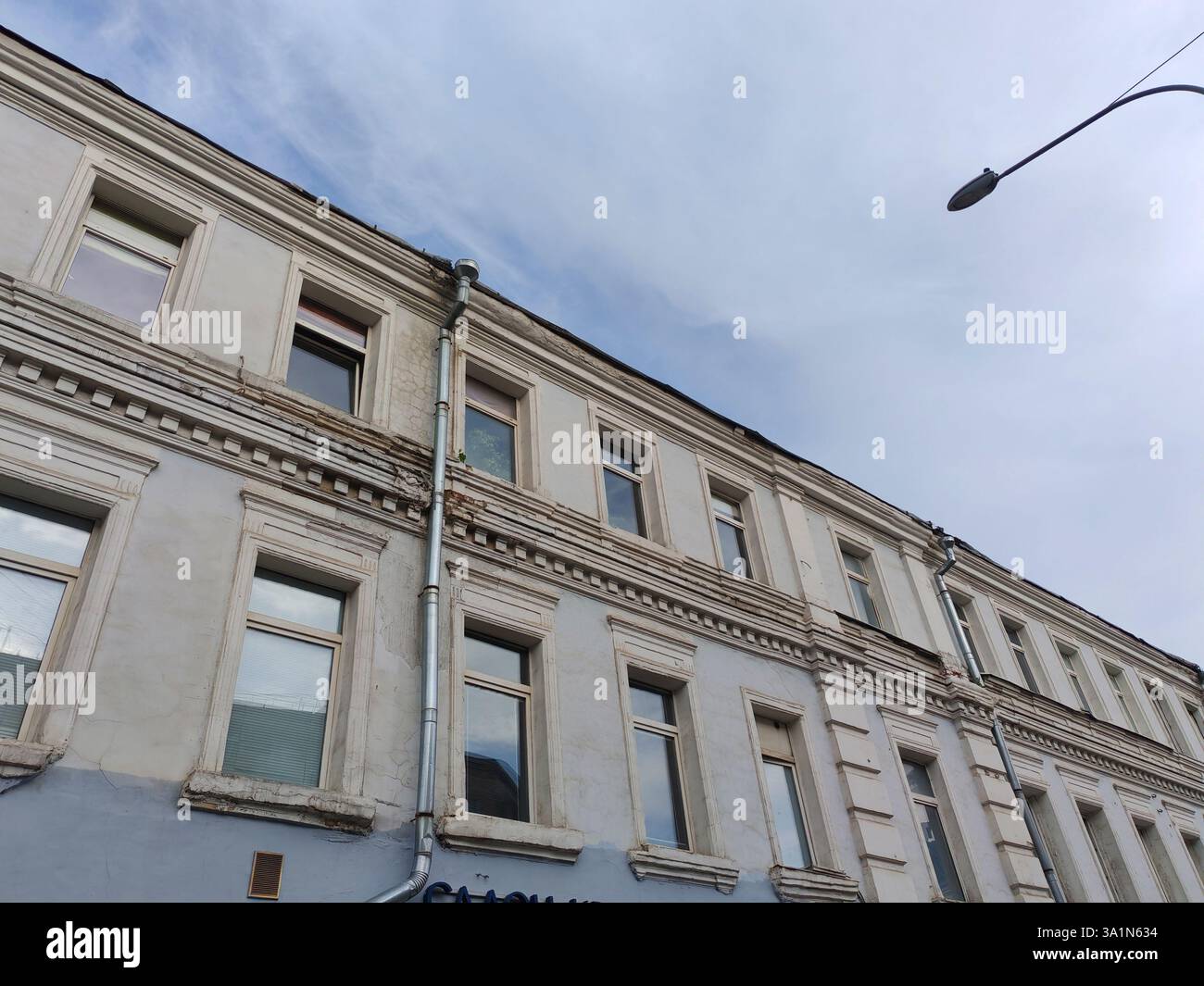 A beige facade with wrought iron canopies, wooden doors, and clean ...
