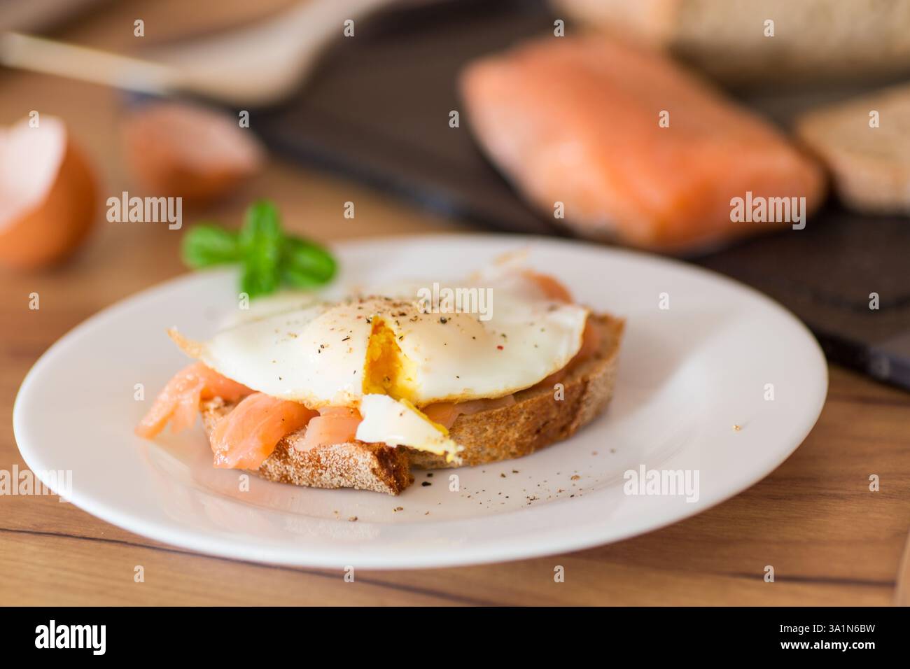 A slice of bread with lightly salted red fish and a cooked egg for ...