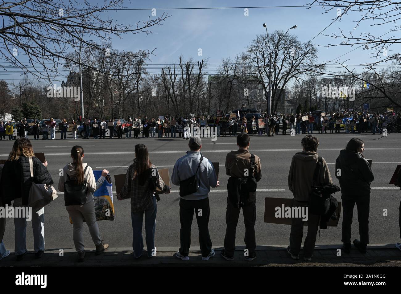 Ukrainian protesters hold signs and flags at a protest in Kyiv, on ...