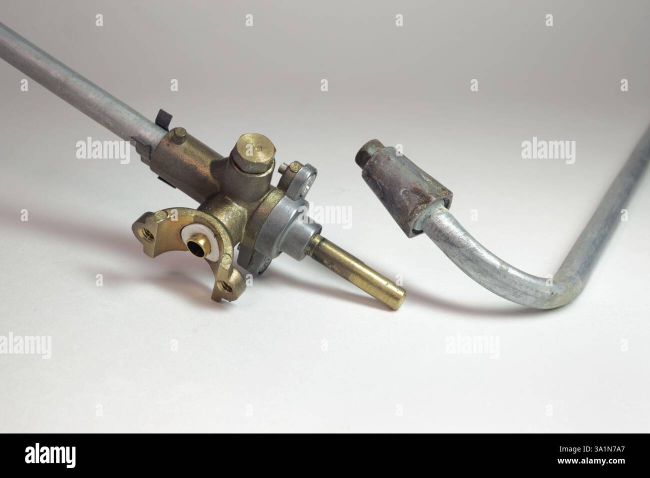 brass valve of surface gas burner and burner nozzle closeup. mounted on ...