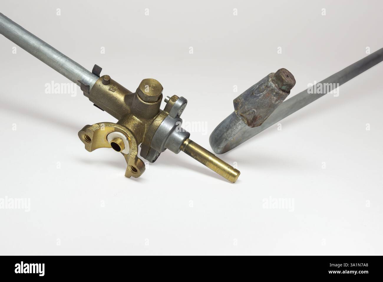 brass valve of surface gas burner and burner nozzle closeup. mounted on ...