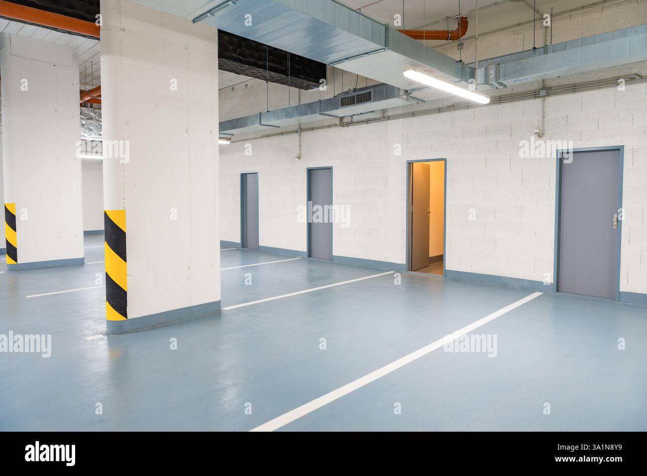 Modern underground parking with storage rooms and industrial ...