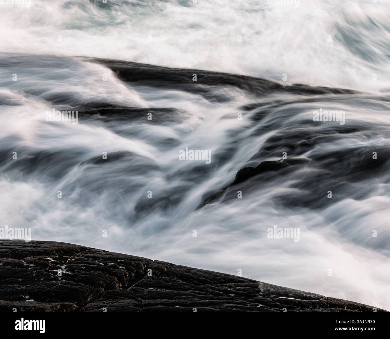 Waves rush energetically against rugged rocks along the Swedish coast ...