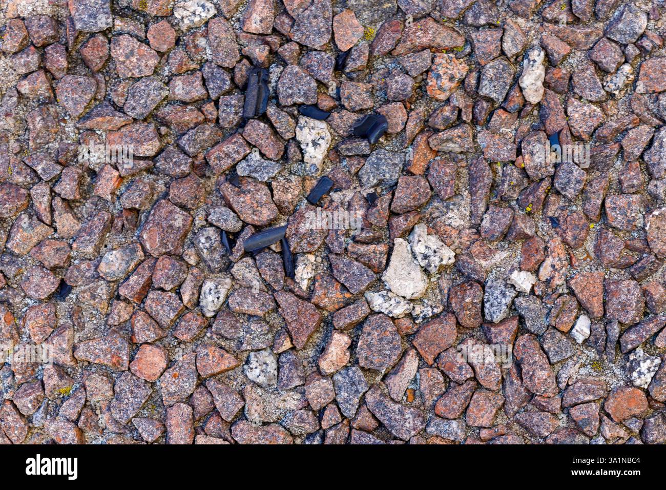 An overhead shot shows irregularly shaped, red-toned rocks set in ...
