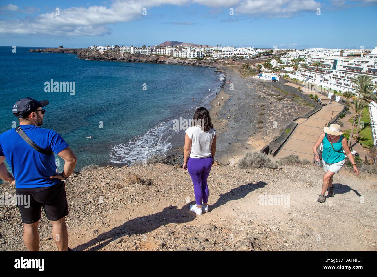People walking the coastal path from Playa Blanca to the beaches at ...