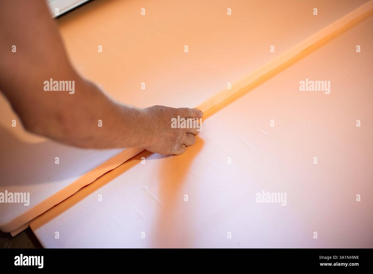 Worker lays polystyrene foam on the floor. Insulation of the house ...