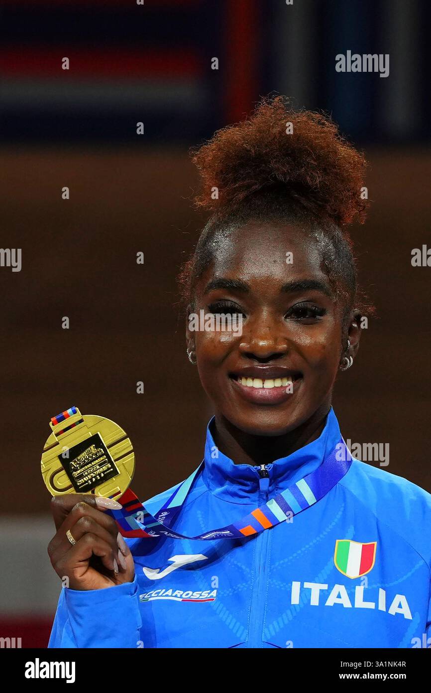 Winner Italy's Zaynab Dosso celebrates on the podium for the 60m Women ...