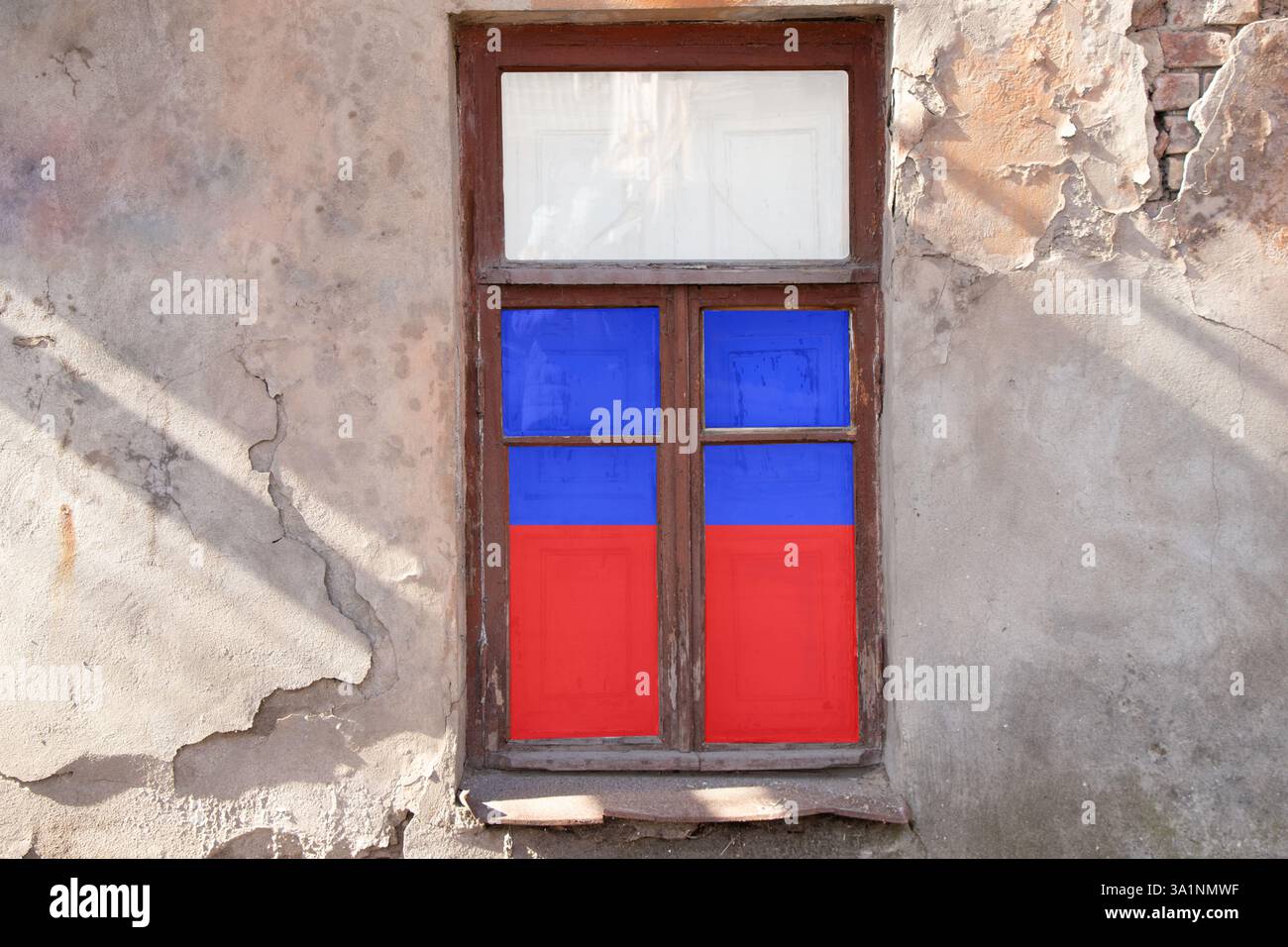 Window on an old house and the Russian flag in the window, poverty and ...