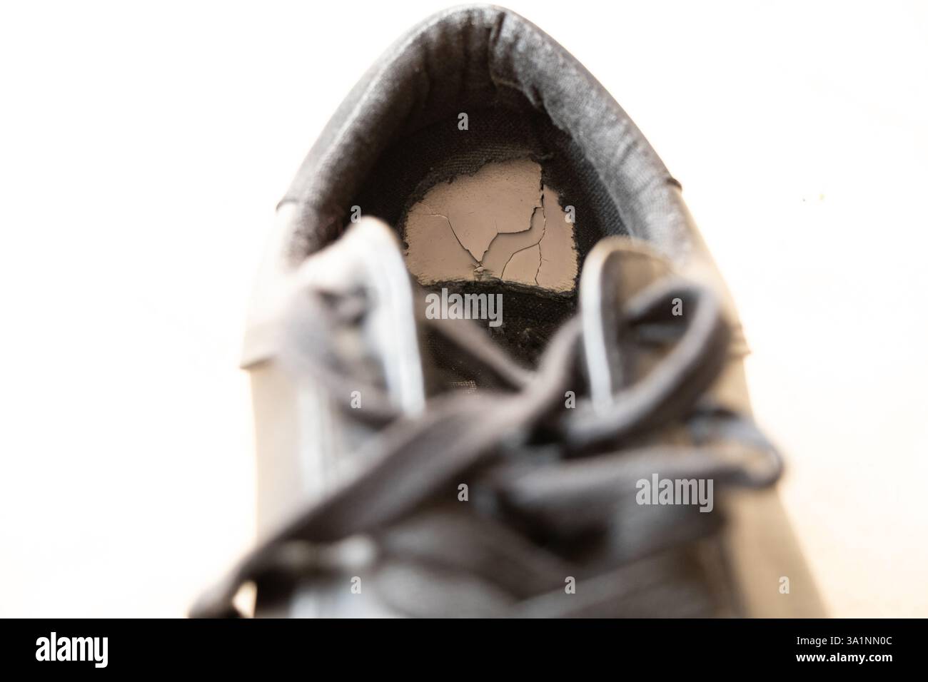 Torn heel in black sneakers inside, torn shoes, wear of poor quality ...