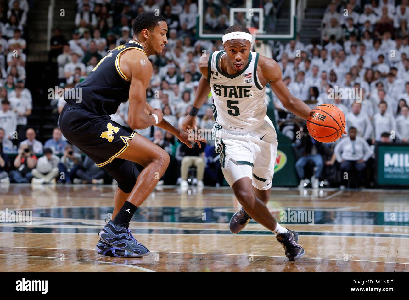 Michigan State guard Tre Holloman (5) drives against Michigan guard ...