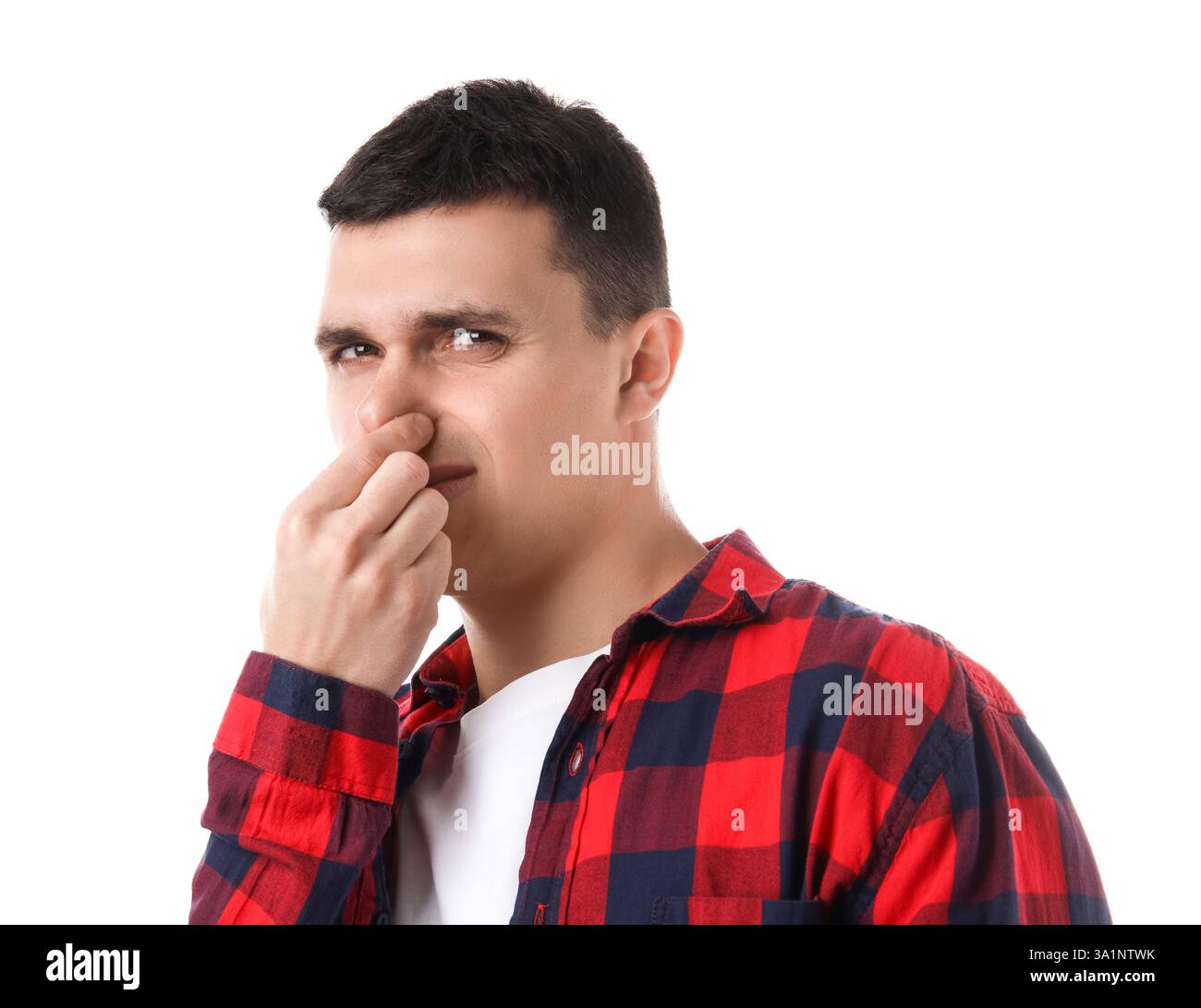 Handsome young man pinching nose because of bad smell on white ...
