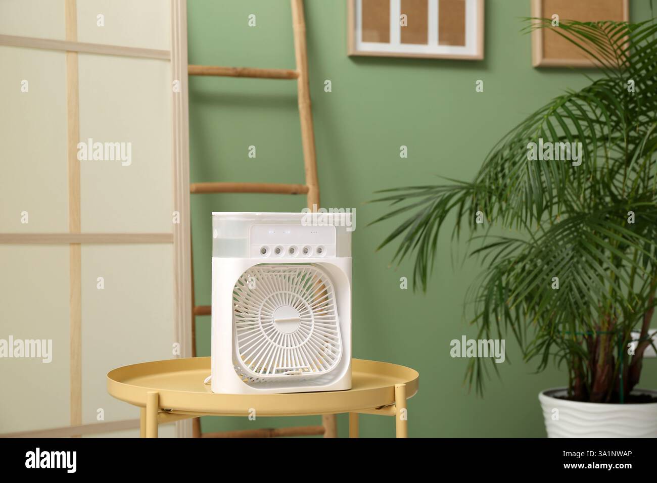 Portable table fan with humidifier on coffee table near folding screen ...