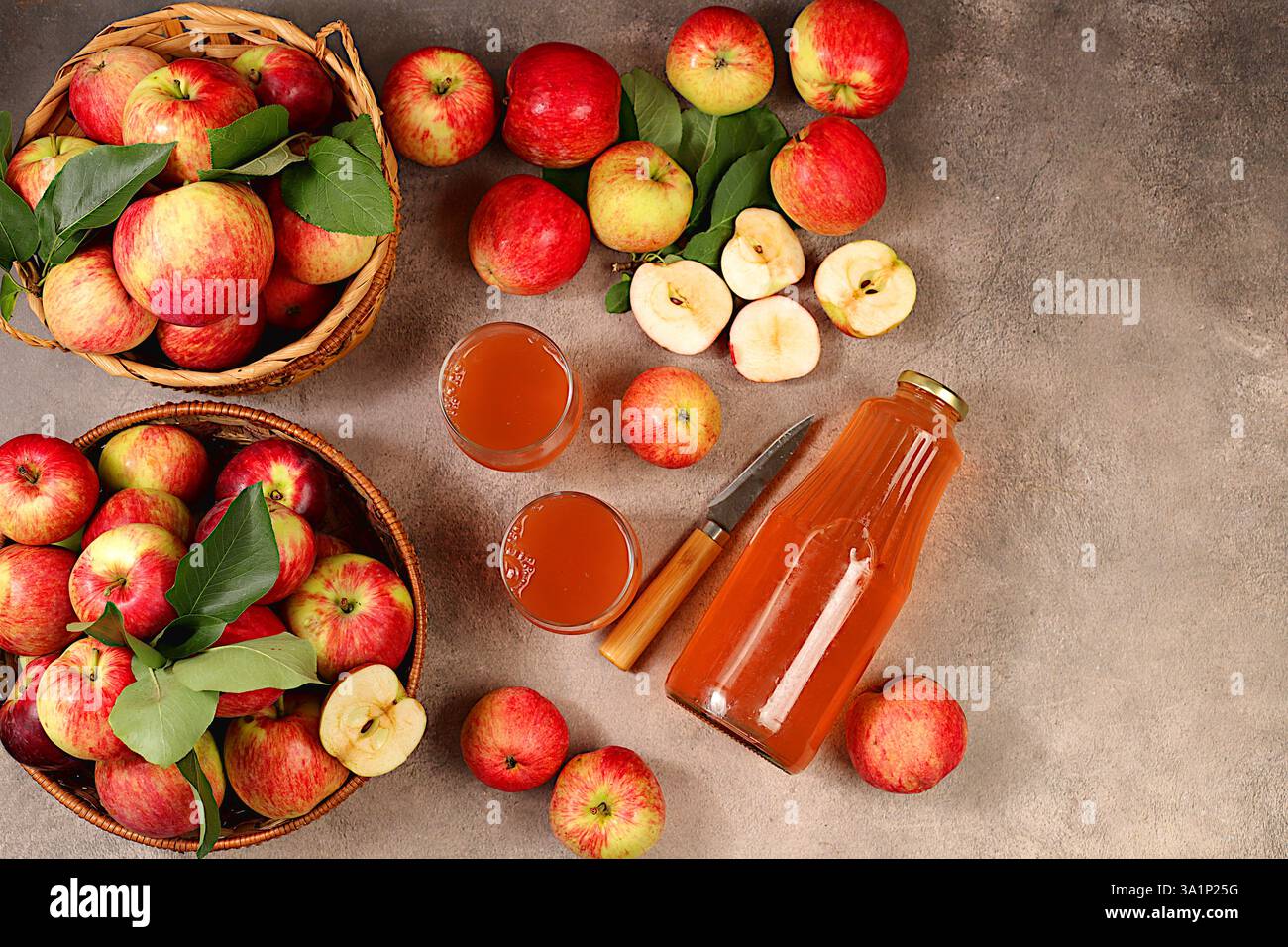 Apple cider, juice or fermented drink and fresh apples on concrete ...