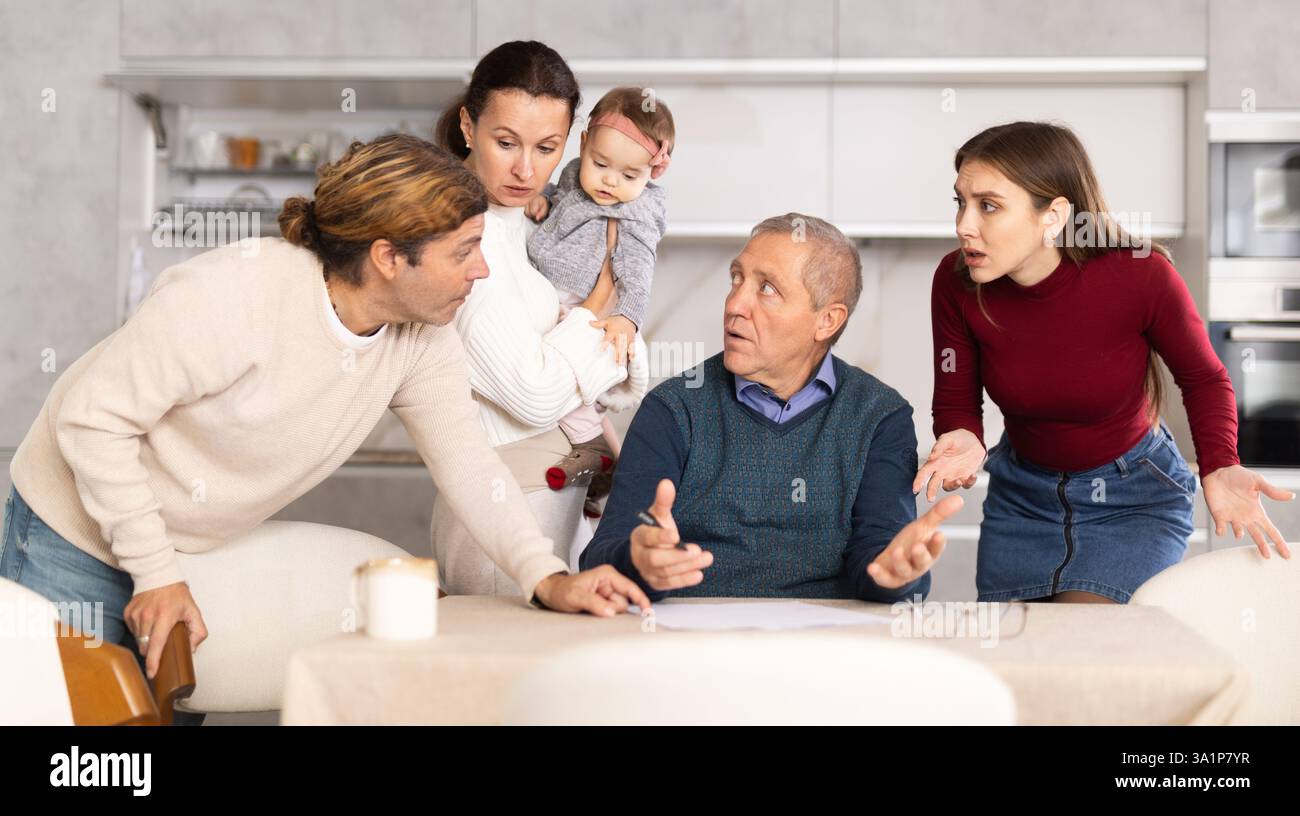 Family of different ages arguing while filling out important documents ...