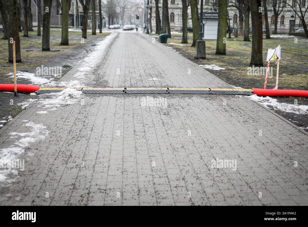 Red Pipe with Yellow Safety Ramp and Caution Sign Blocking Pathway ...
