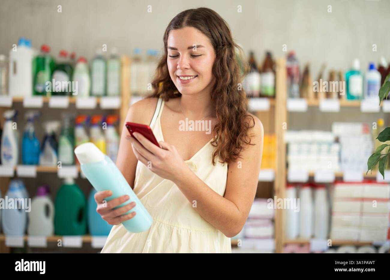 Young woman scanning qr code for shampoo or shower gel Stock Photo - Alamy