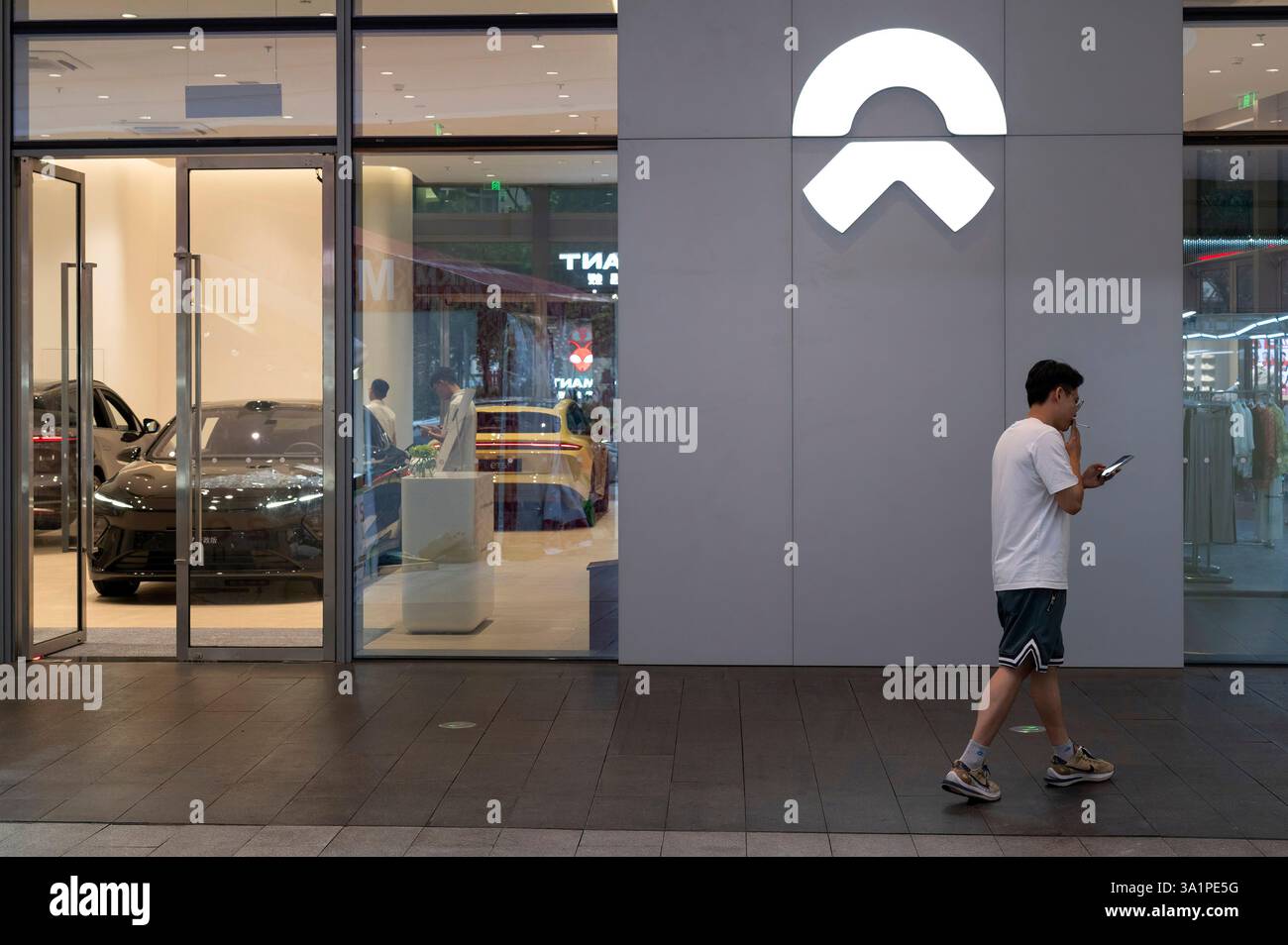Pedestrians walk past the Chinese electric (EV) automobile company NIO ...
