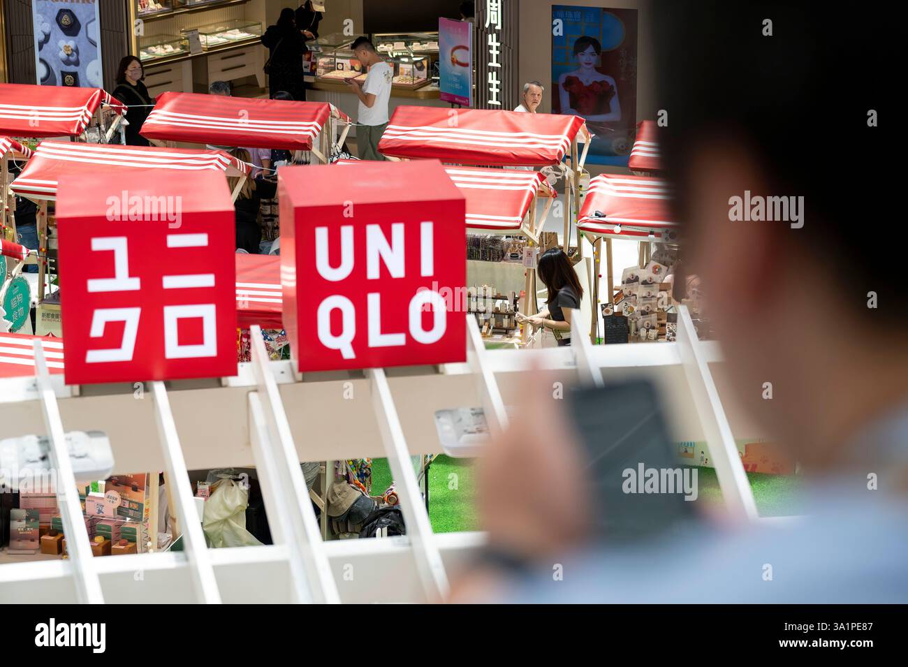 Shoppers are seen outside the Japanese clothing brand Uniqlo store in ...