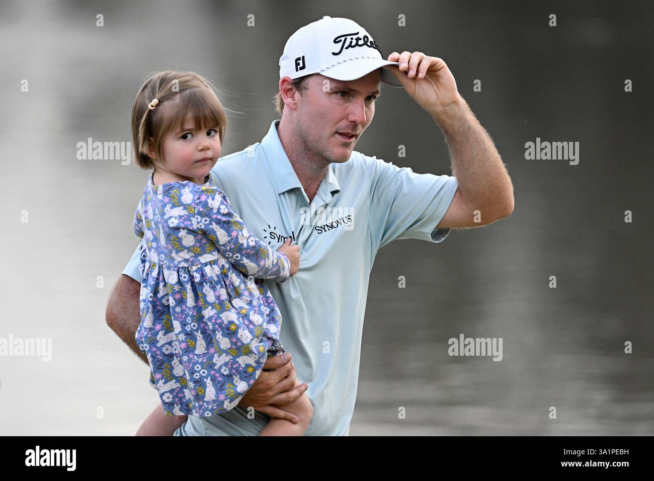 Russell Henley, right, carries his daughter Jane, 2, on the 18th green ...