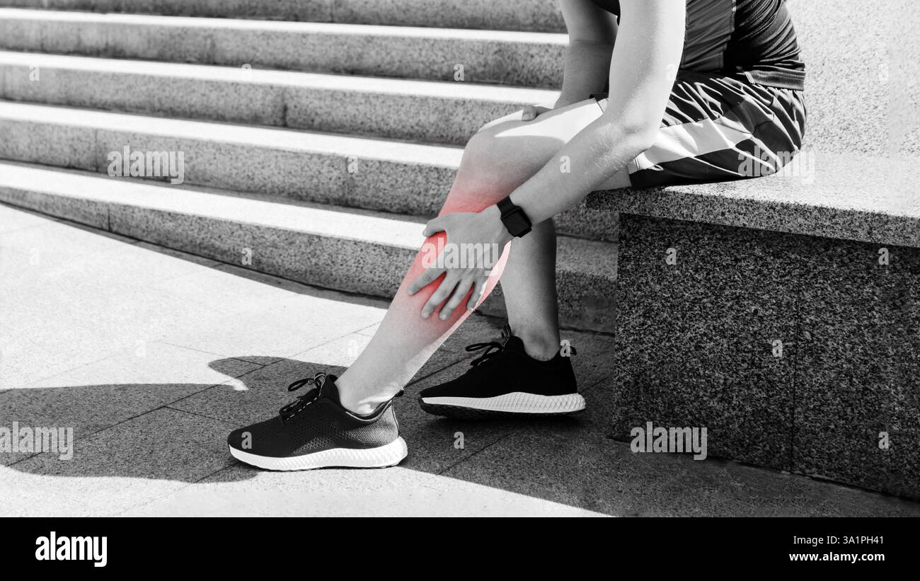 Leg injury. Guy with expression of pain on face, sits and rubs leg ...