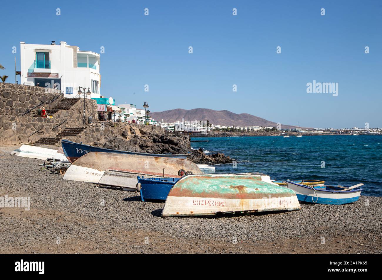 Small fishing boats on the pebble beach at the Spanish holiday resort ...