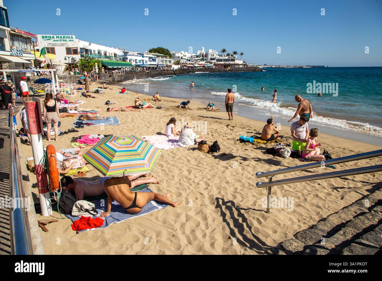 Tourists and holidaymakers on the beach for winter February sunshine at ...