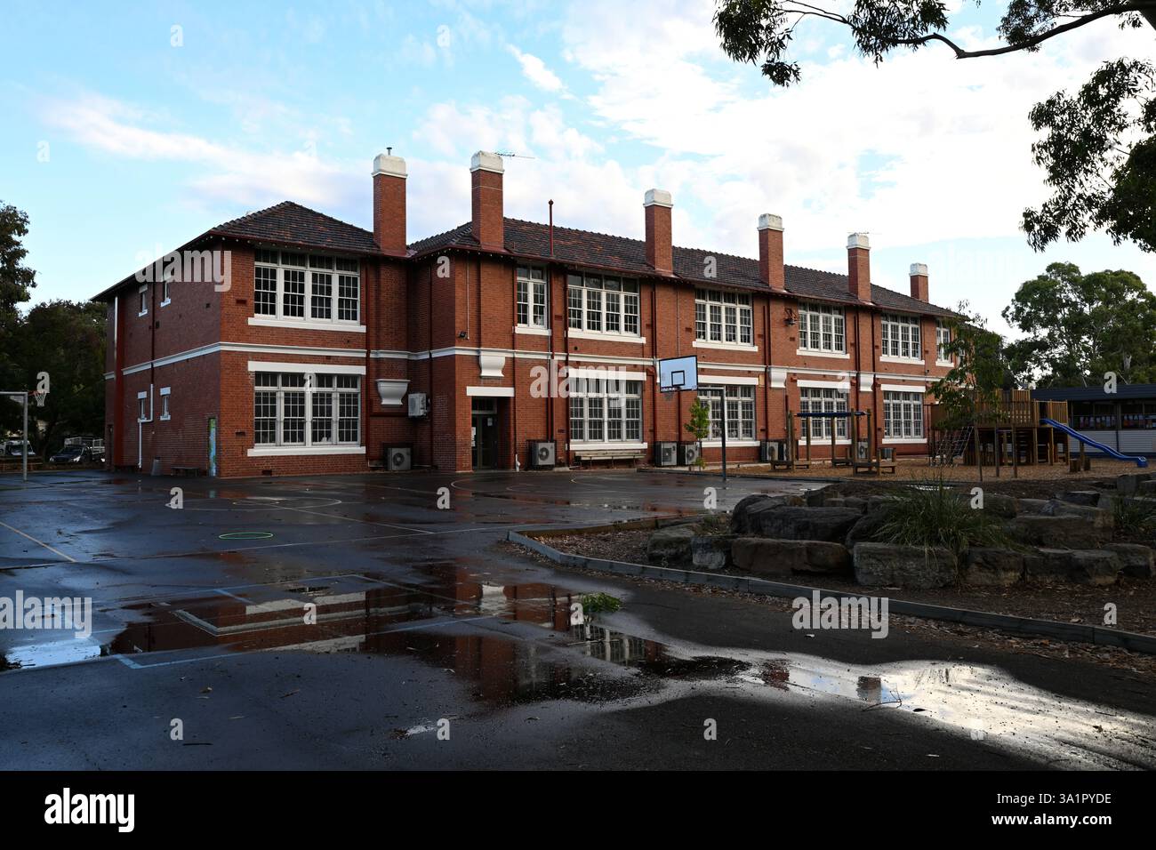 Elwood Primary School's paved schoolyard and main building, an old red ...