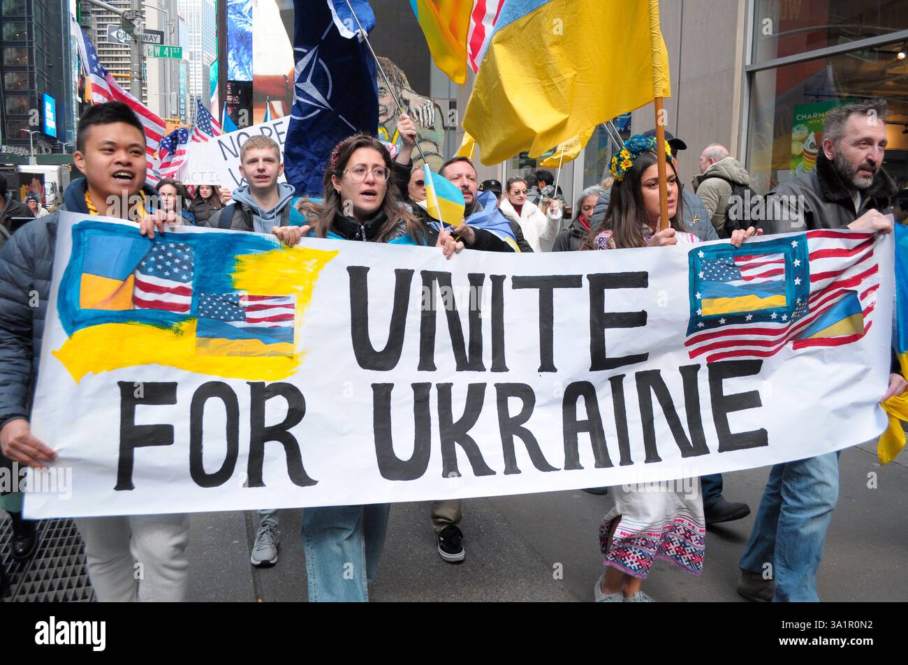 Pro-Ukraine demonstrators march holding a banner. Demonstrators ...