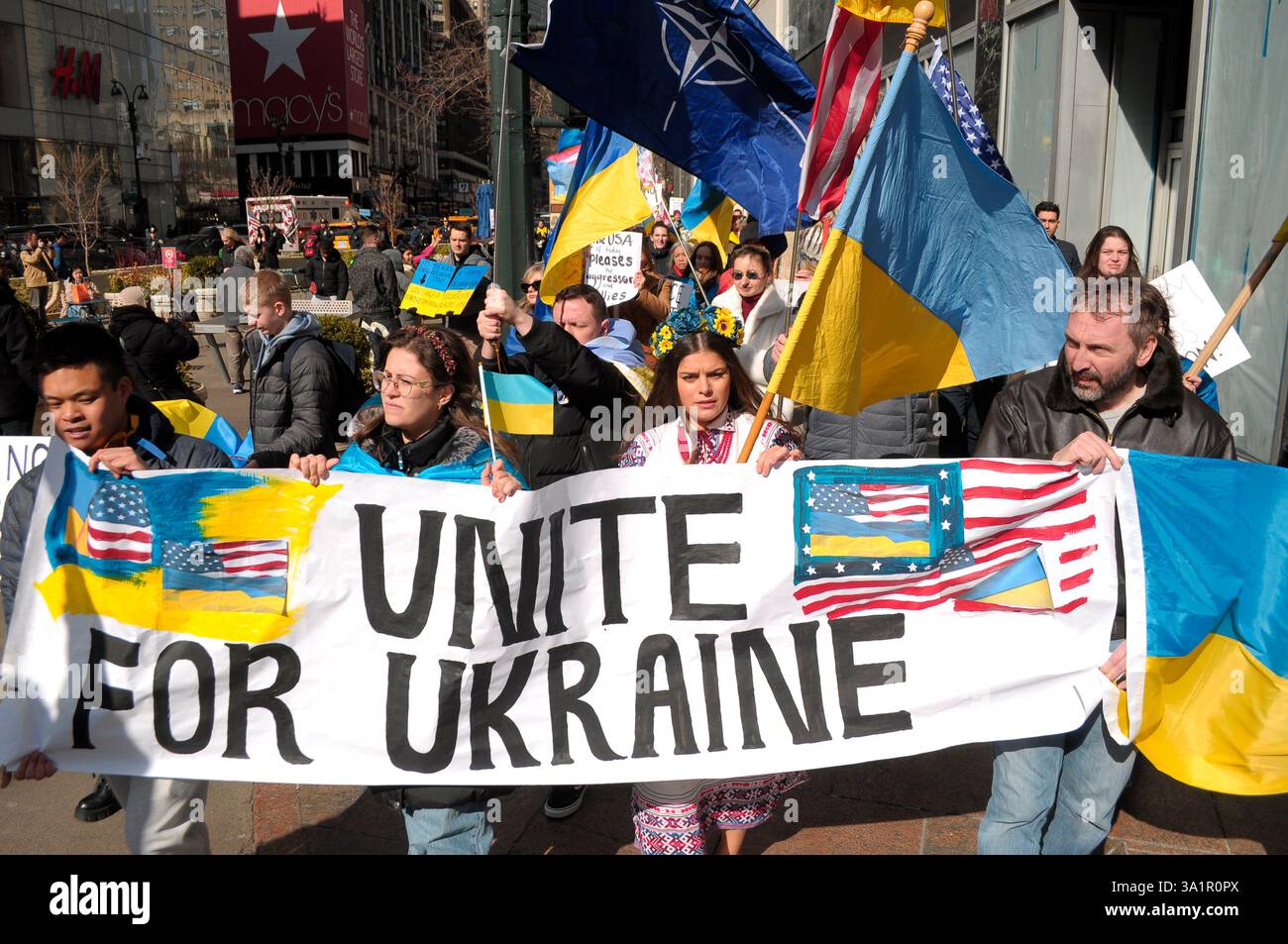 Pro-Ukraine demonstrators march holding a banner. Demonstrators ...