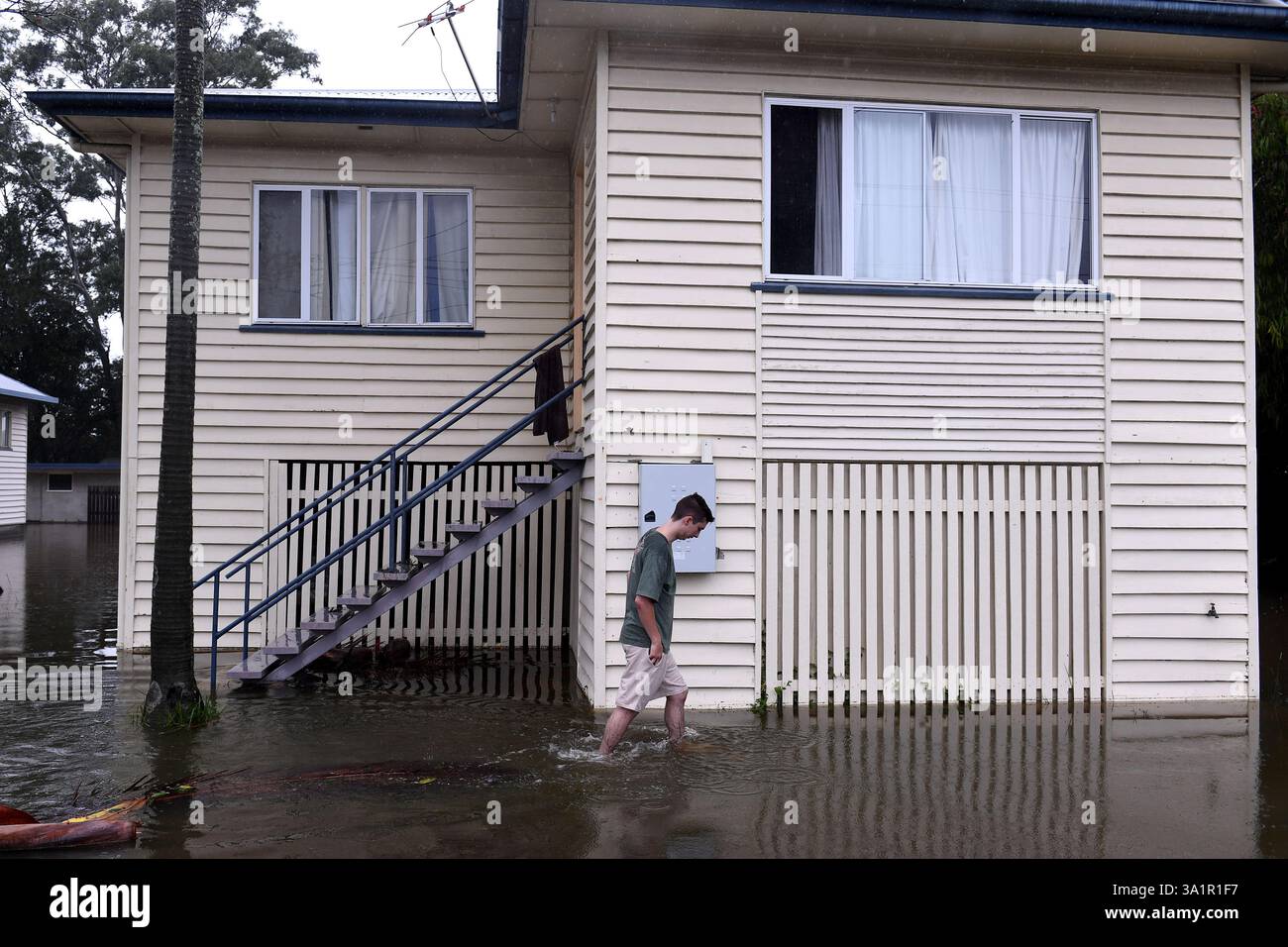 Hayden Edwards walks near his flooded house in Oxley in Brisbane ...