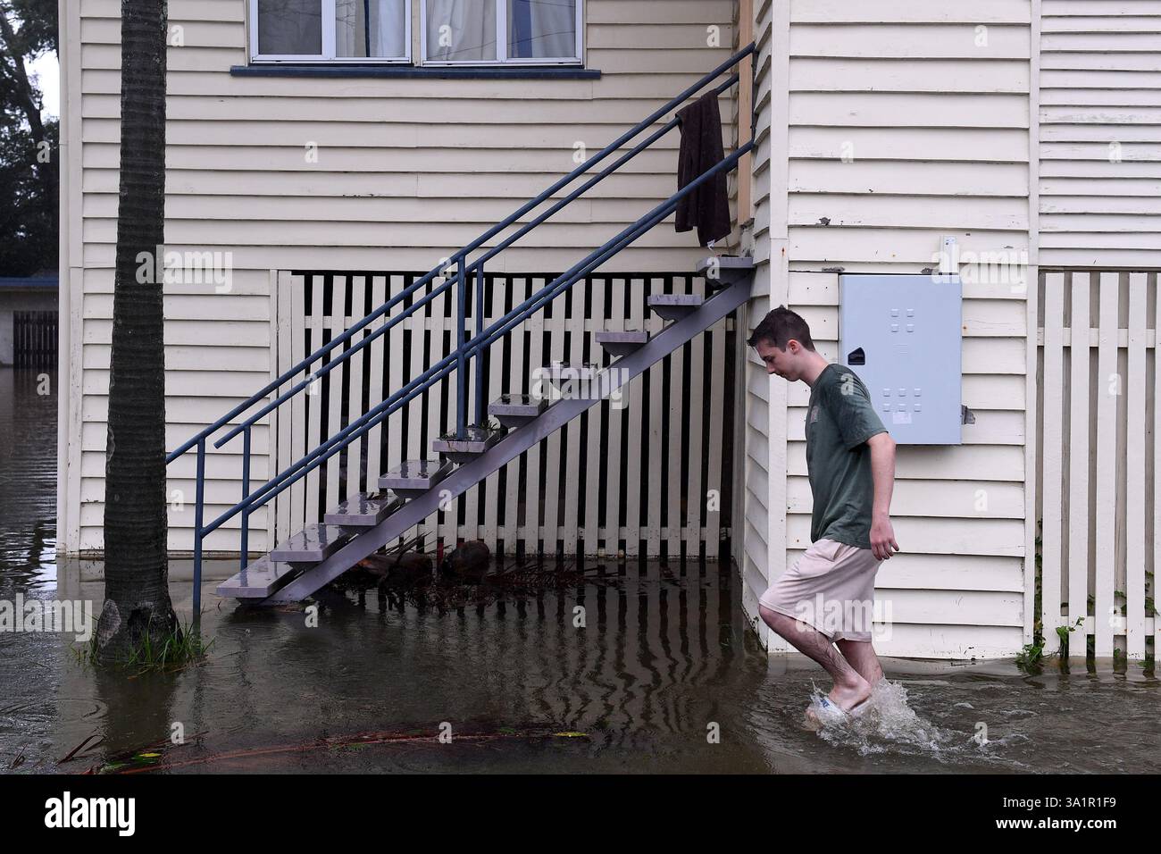 Hayden Edwards walks near his flooded house in Oxley in Brisbane ...