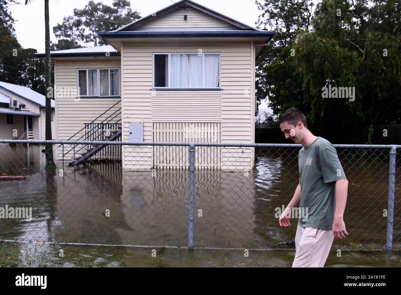 Hayden Edwards walks near his flooded house in Oxley in Brisbane ...