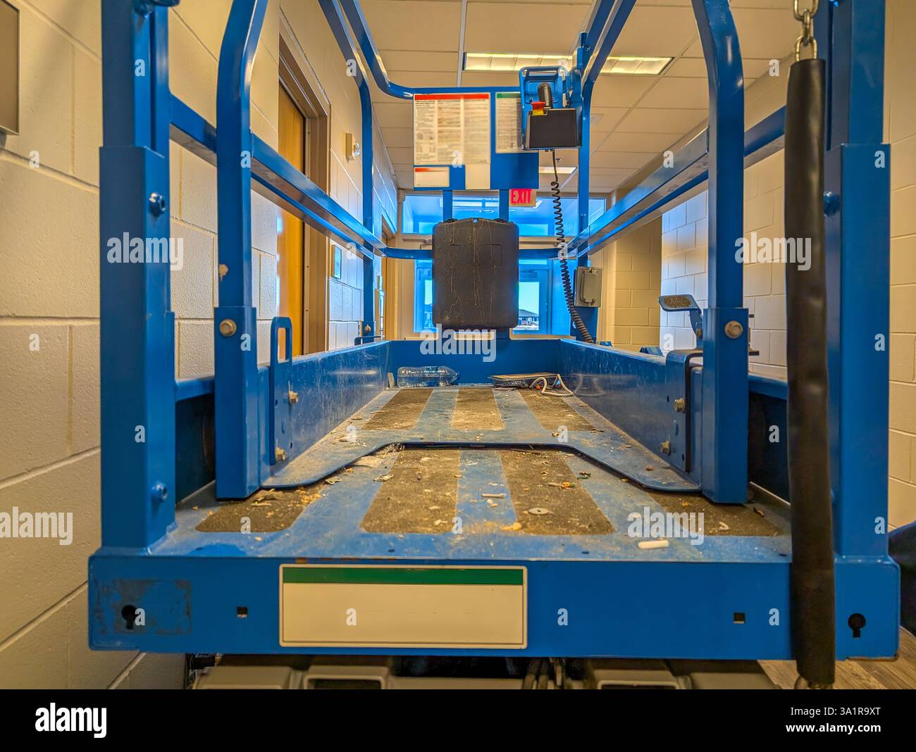 open gate to a scissor lift lowered inside a building construction ...