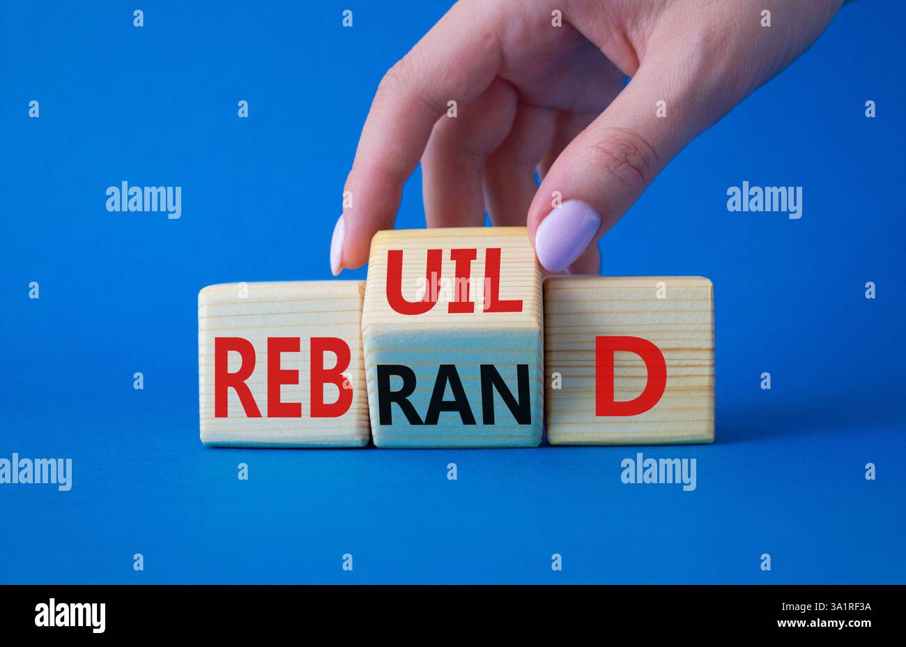 Rebuild and Rebrand symbol. Businessman hand turns wooden cubes and ...