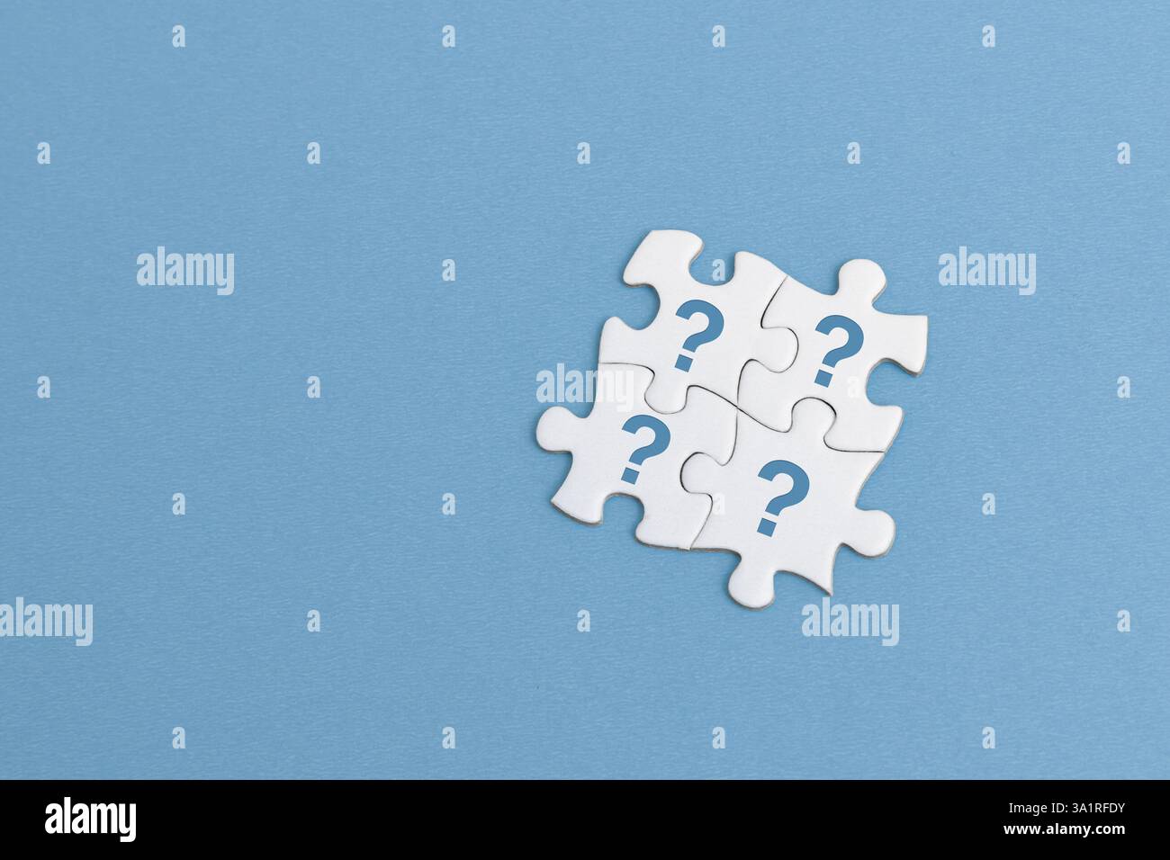 Four white puzzle pieces featuring blue question marks, symbolizing ...