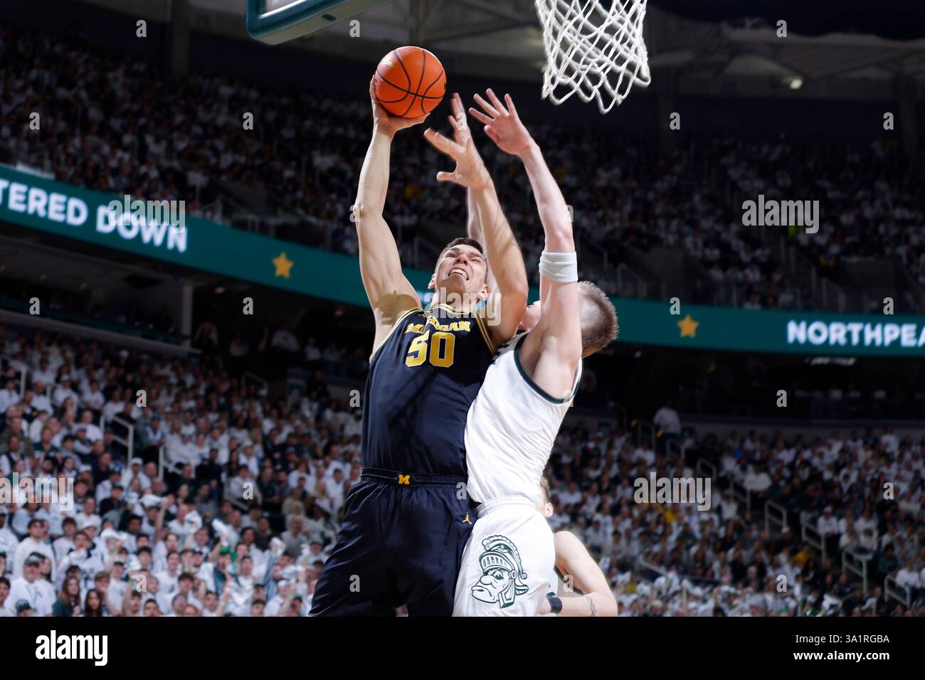 Michigan center Vladislav Goldin (50), left, shoots against Michigan ...